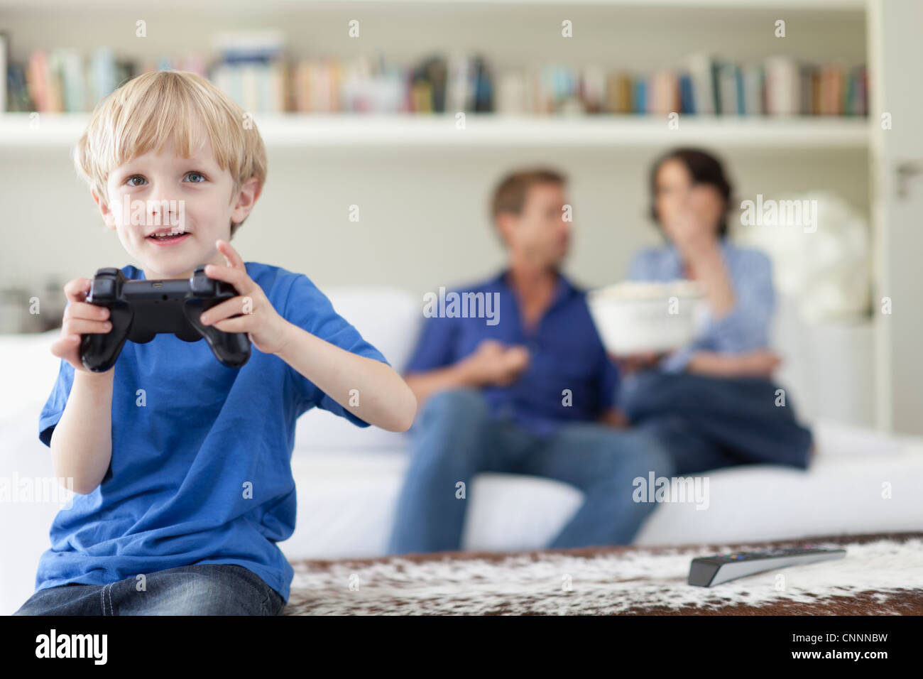 Boy playing video games in living room Stock Photo - Alamy