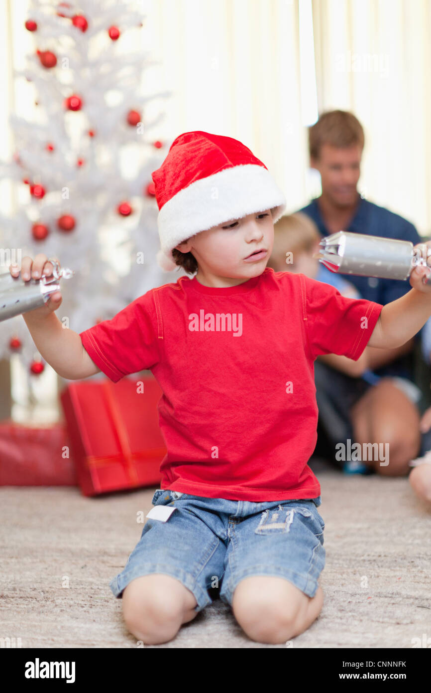 Boy opening Christmas cracker by himself Stock Photo - Alamy