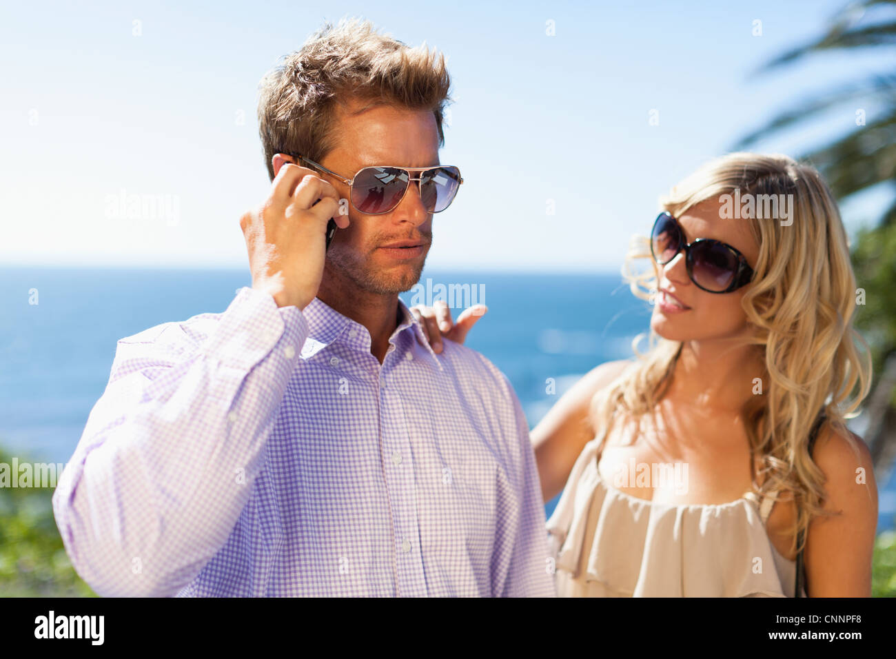 Man ignoring girlfriend for cell phone Stock Photo - Alamy