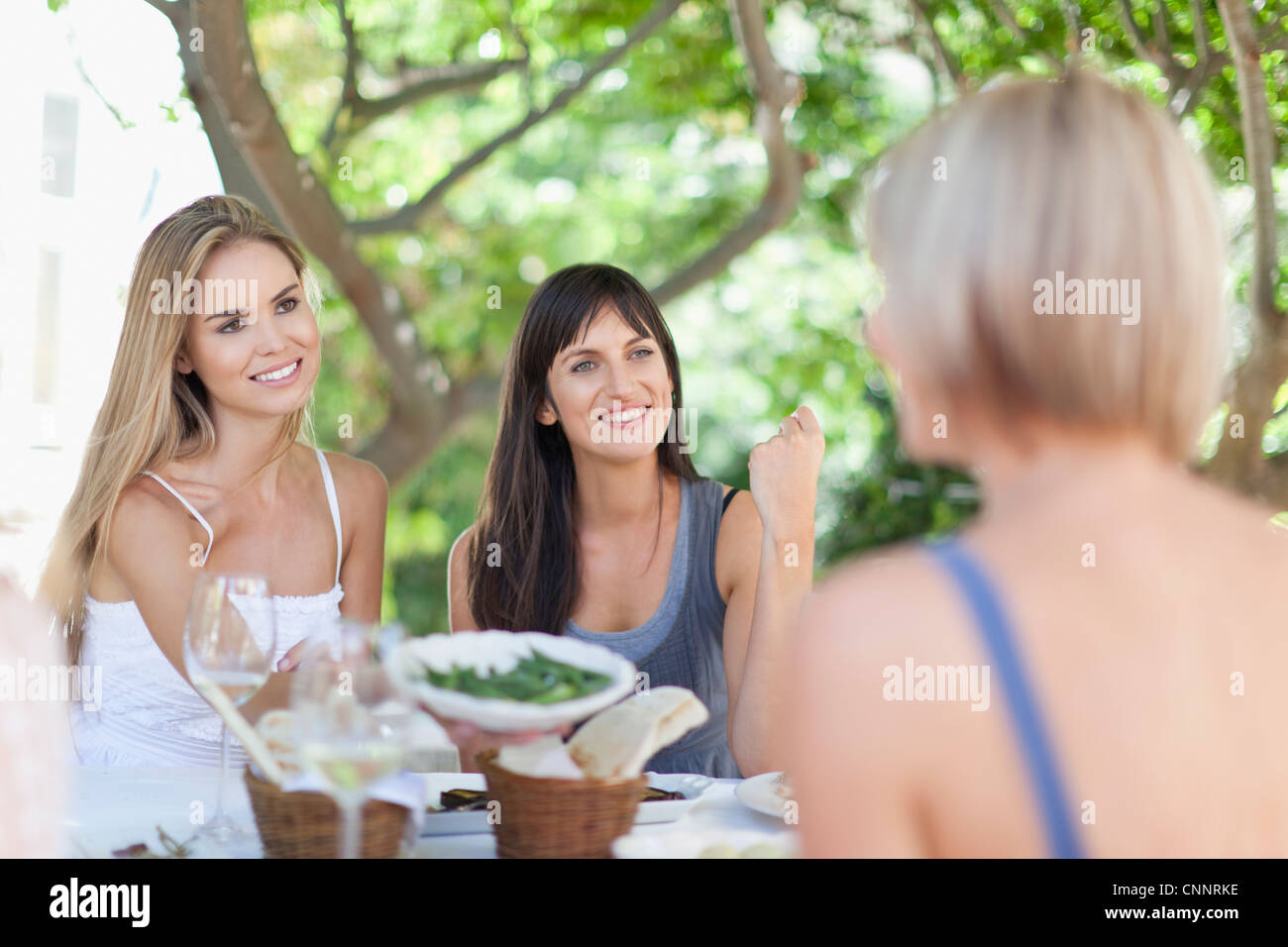 Women eating at table outdoors Stock Photo - Alamy