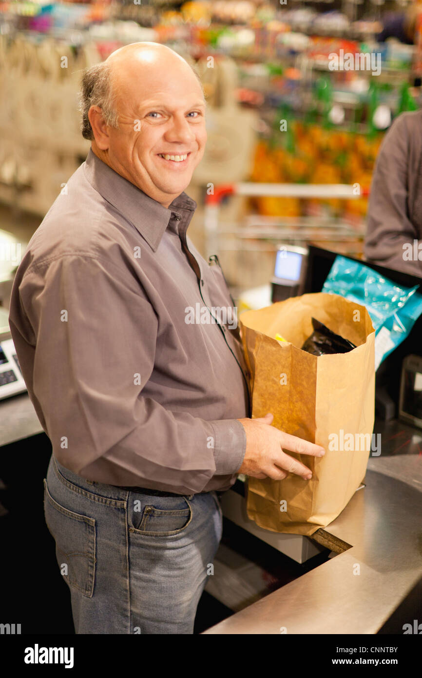 Clerk bagging groceries in store Stock Photo - Alamy