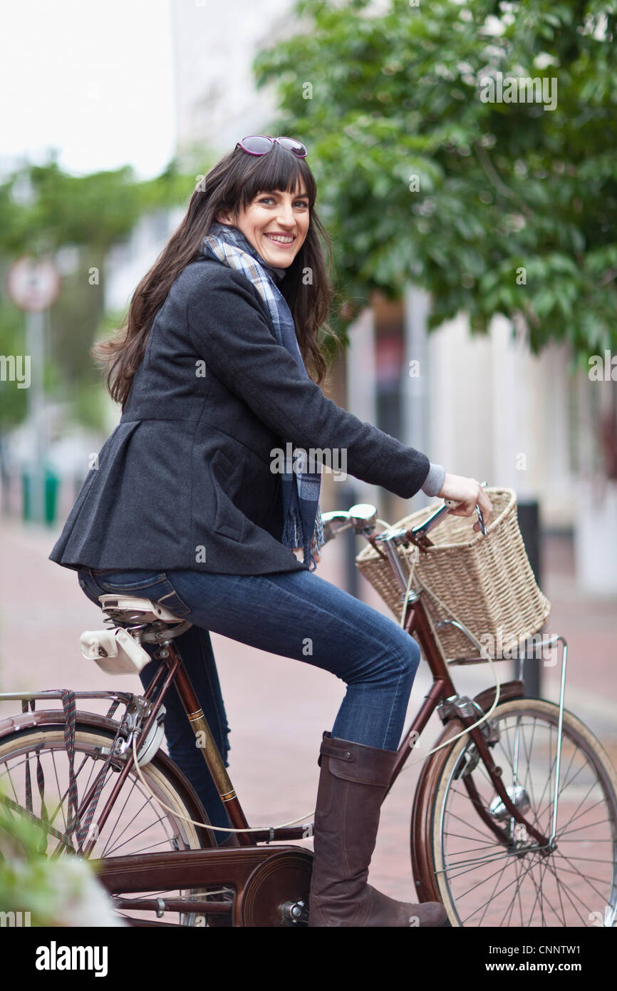 Smiling woman riding bicycle in city Stock Photo - Alamy