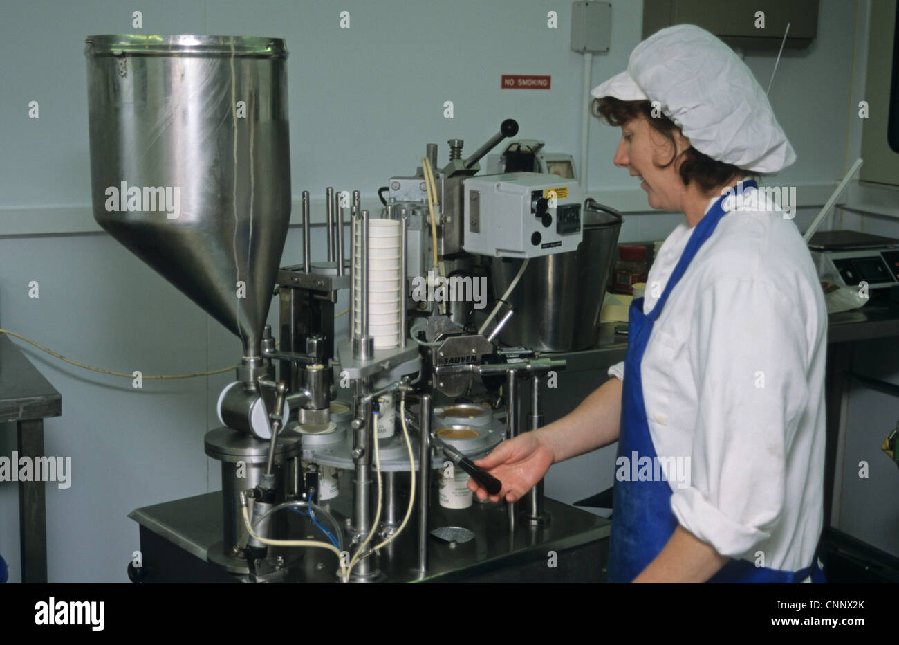 Dairy farming, worker using machine for cream production, Prosperous ...