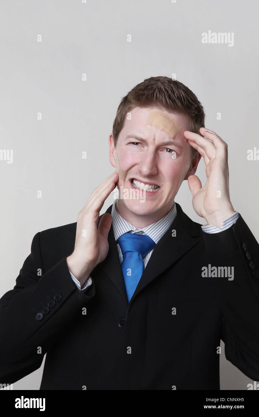 businessman with plasters on his face looking hurt and unhappy Stock ...