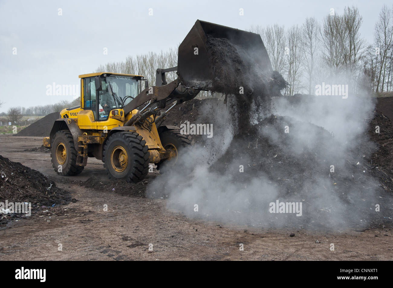 Volvo loader turning green compost waste for aeration at municipal ...
