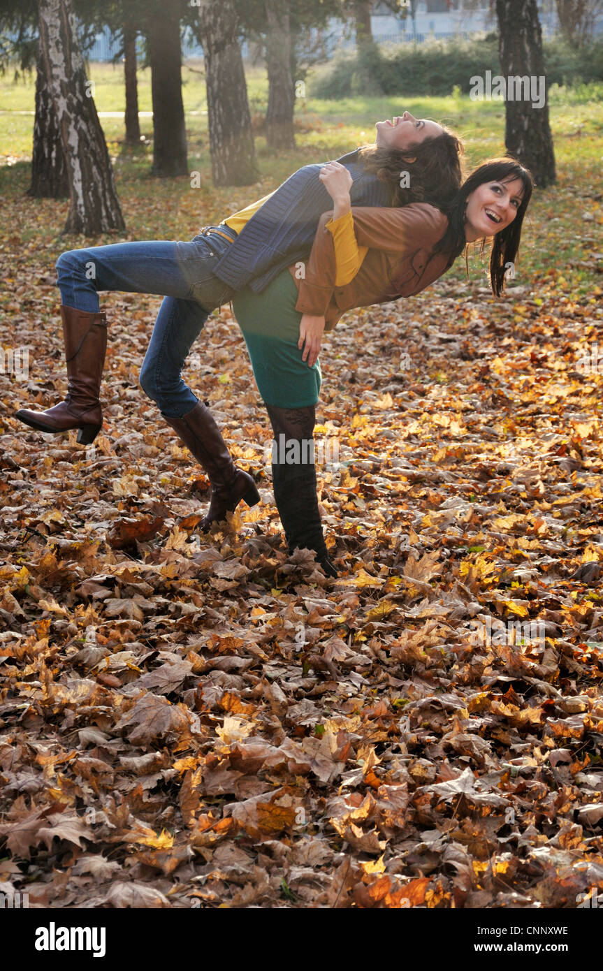 Young woman lifting friend on her back Stock Photo - Alamy