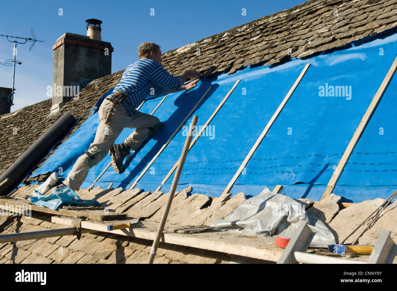 Man tiling roof with slate rock Stock Photo - Alamy