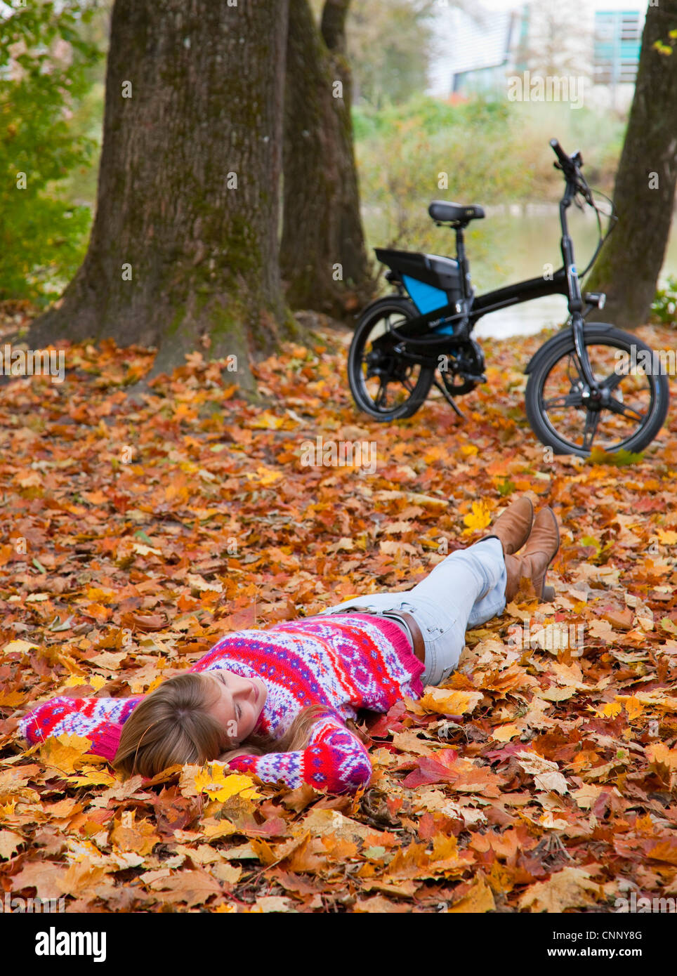 Woman laying in fall leaves Stock Photo - Alamy