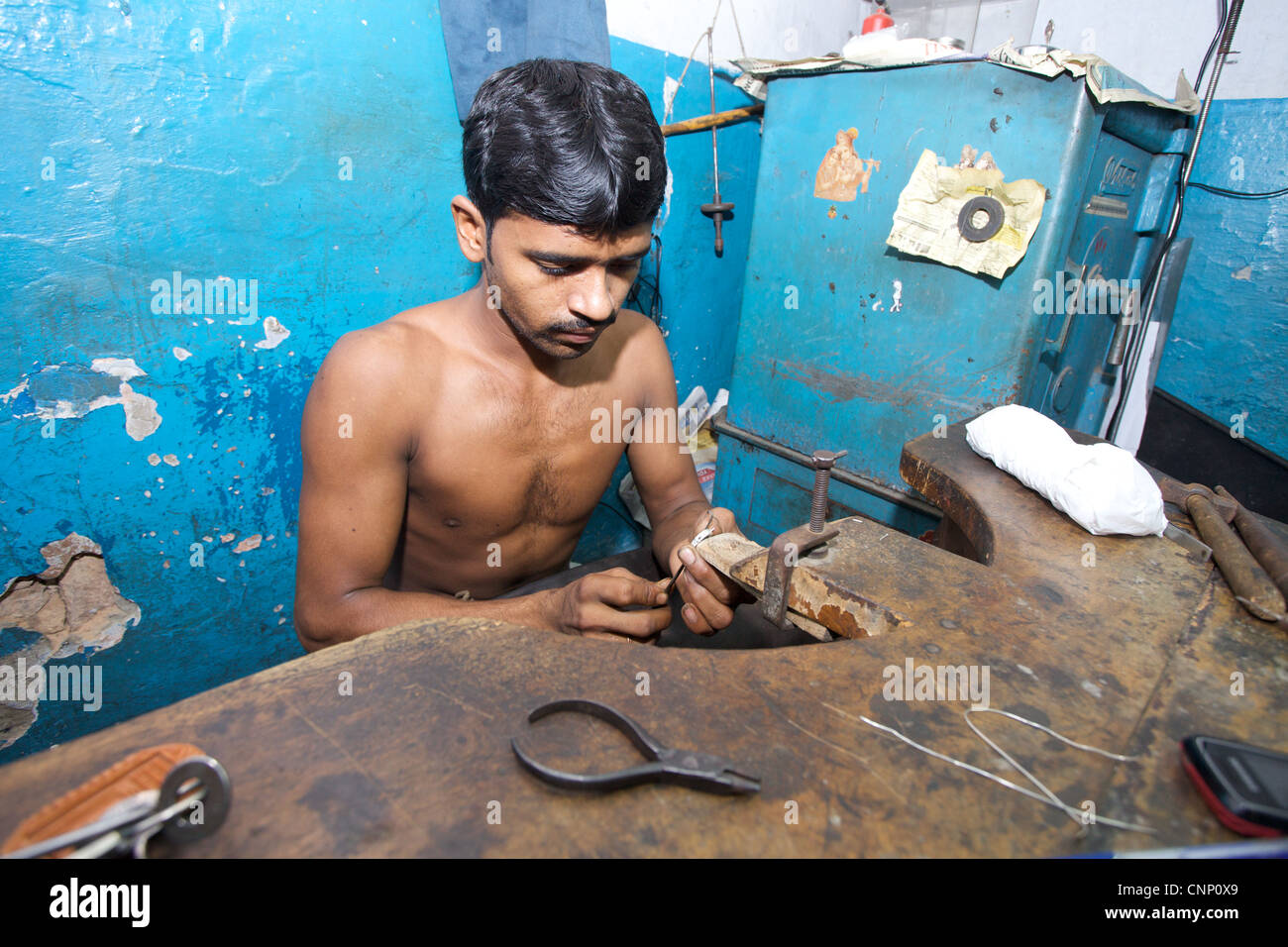A diamond setter working in his small studio in Old Delhi, India Stock ...