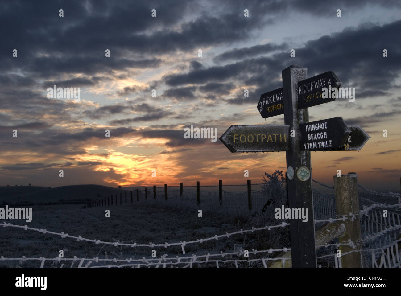 Frost covered footpath sign and fence at sunset, Ridgeway Path, near ...