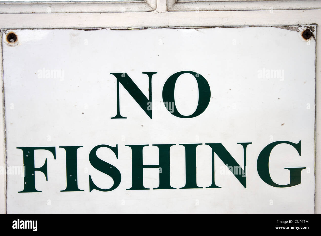 A square white sign stating no fishing Stock Photo - Alamy