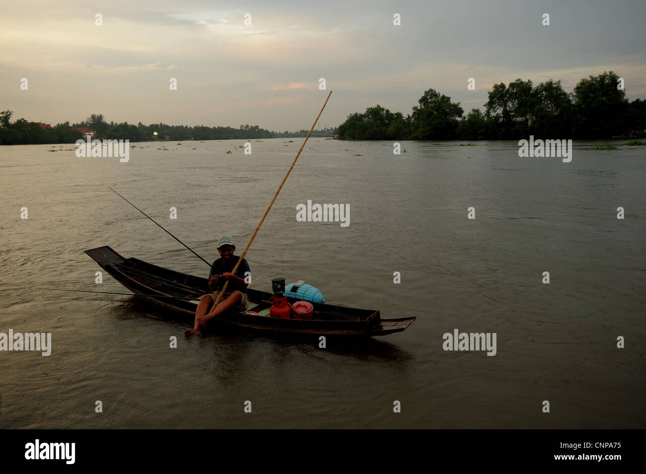 thai fisherman fishing with two fishing rod,sunset on the mae klong ...