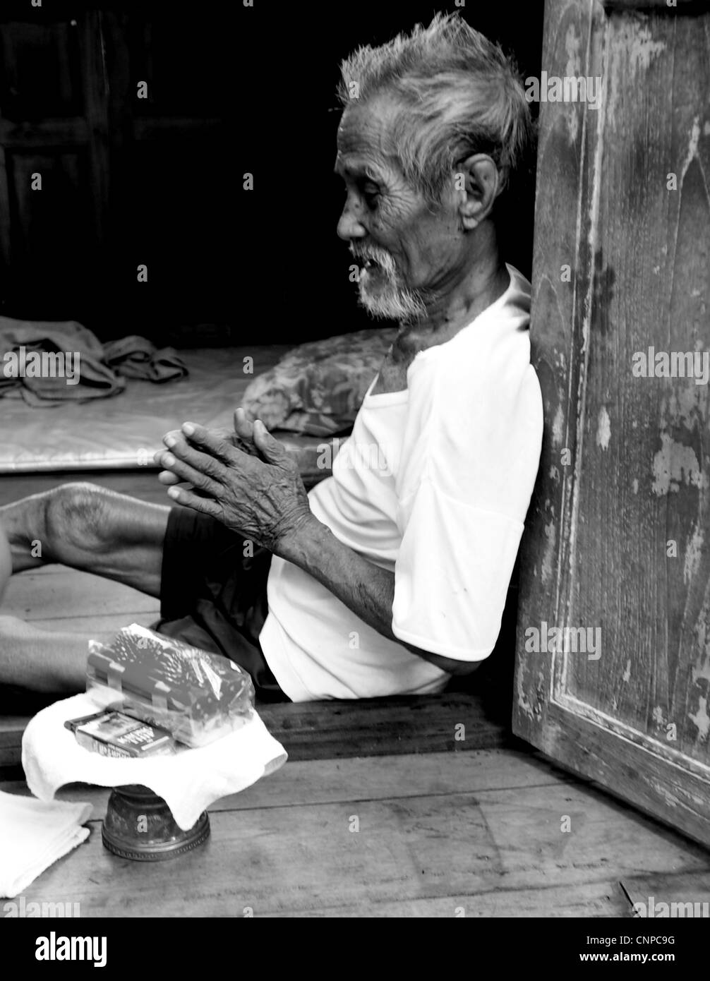 old man recieving gifts from monk to be , temple on the bank of Mae ...