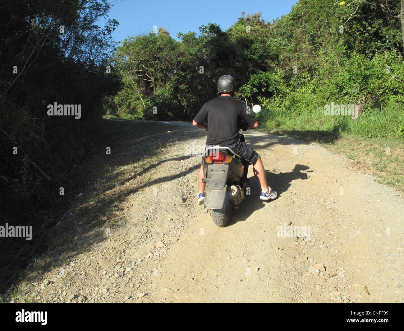 Man riding along country road in Roatan, Honduras Stock Photo - Alamy