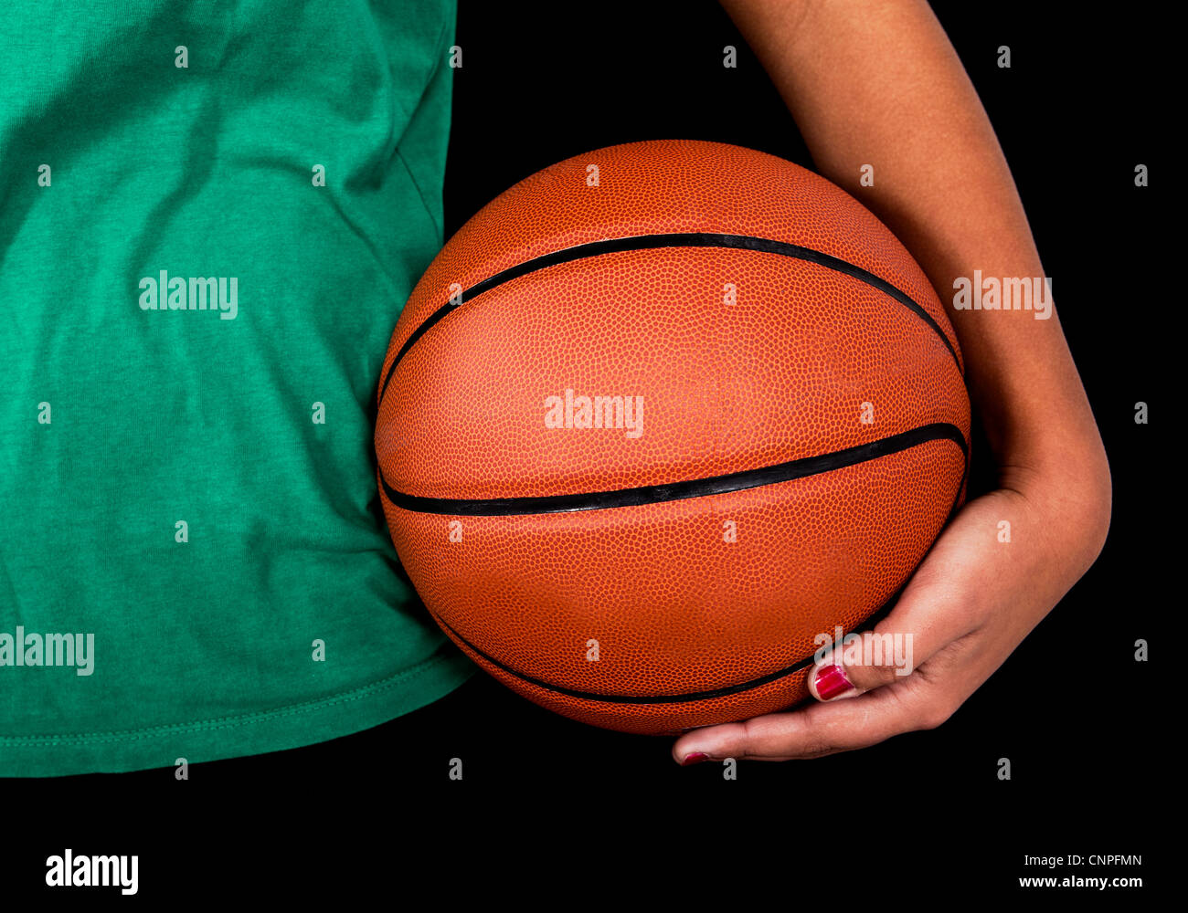 Close-up of a basketball with woman holding it. Studio shot with black ...