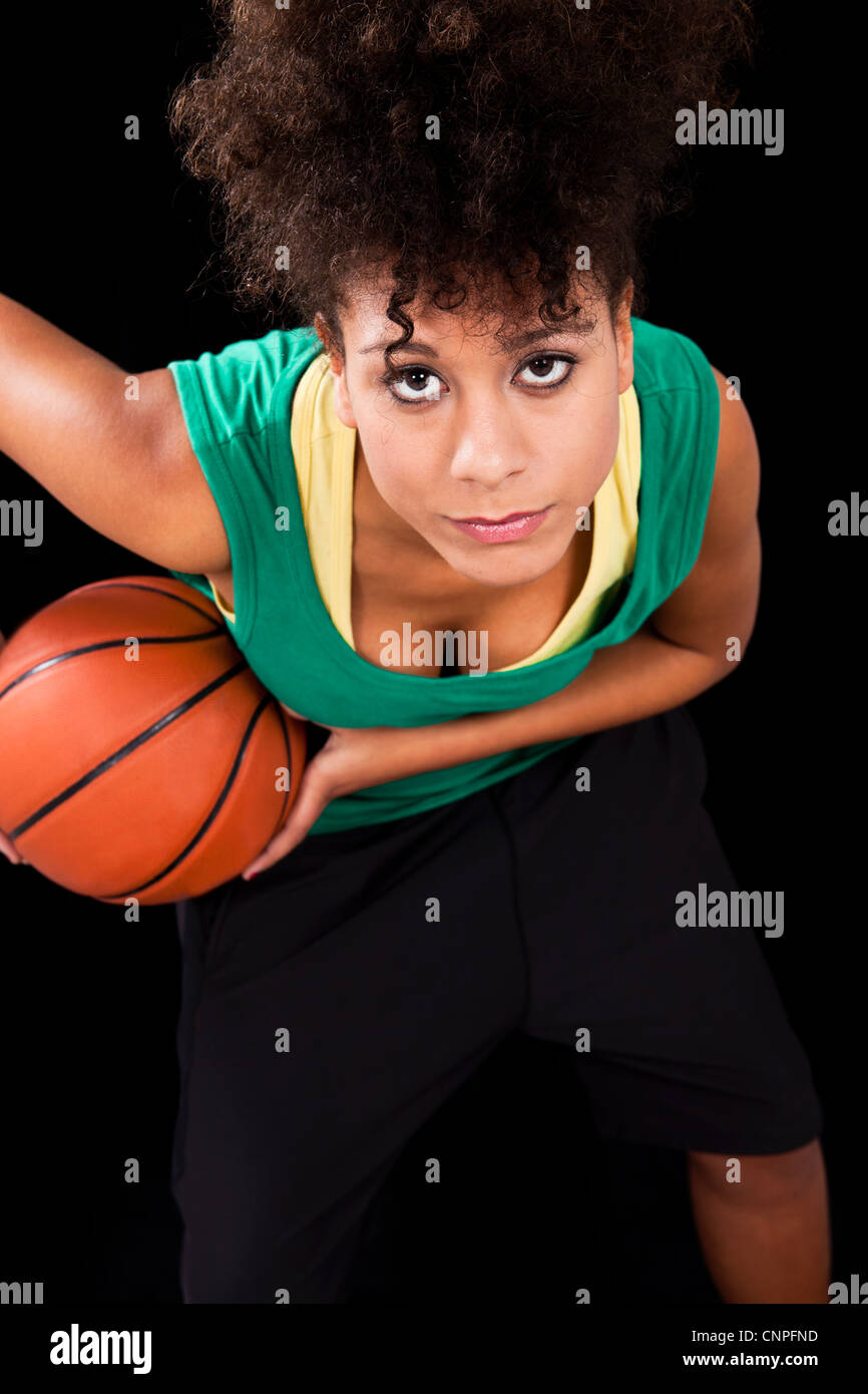 Athletic woman with a basketball. Studio shot with black background ...