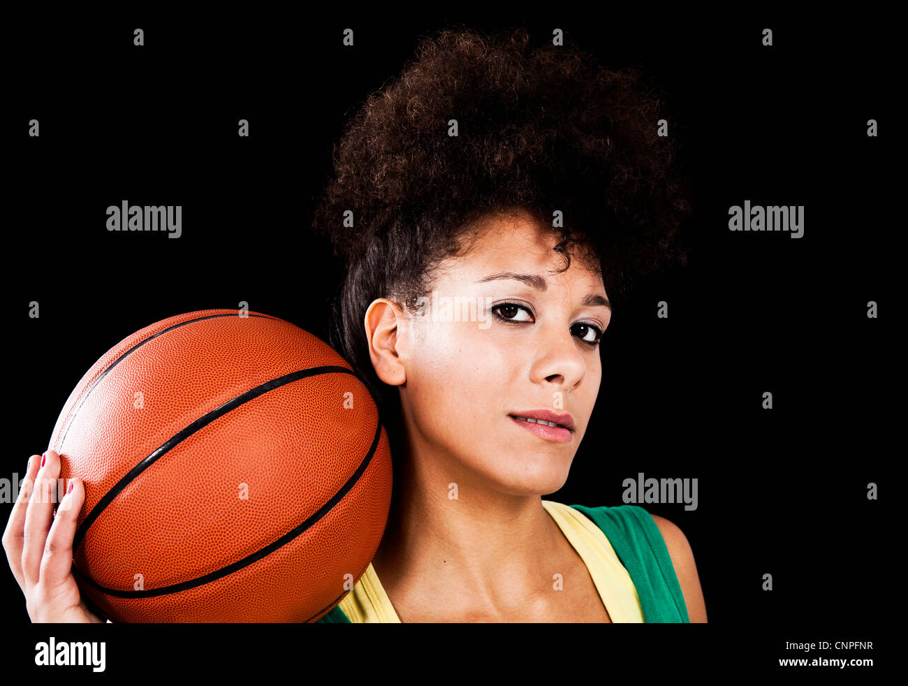 Athletic woman with a basketball. Studio shot with black background ...