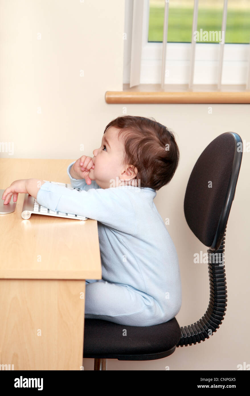 Young baby looking up at computer Stock Photo - Alamy