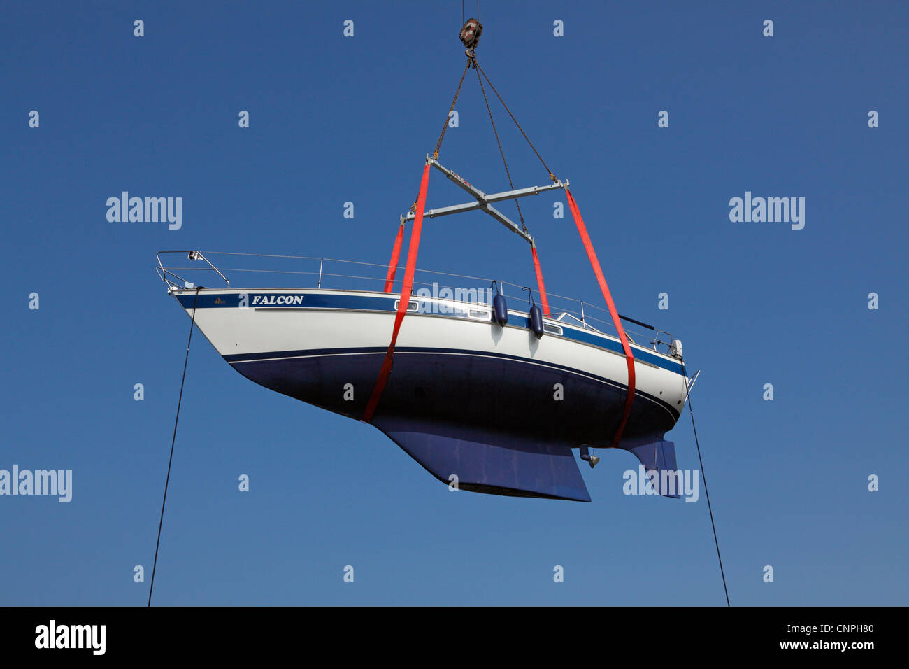 Sailing boat being hoisted into the harbour by a crane for the summer ...