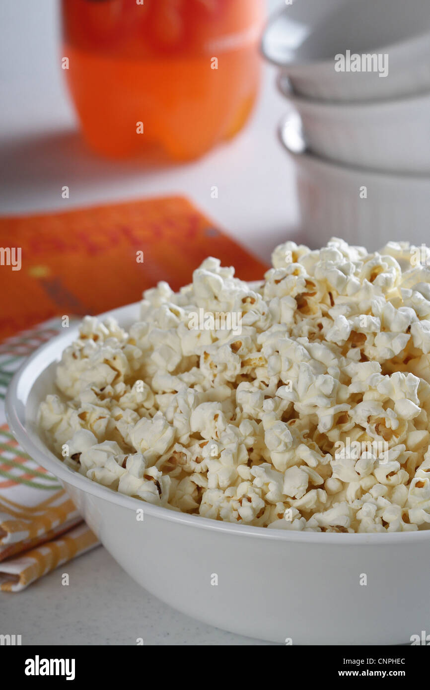 A bowl of popcorn with a cup towel and napkin, and 3 empty bowls and ...