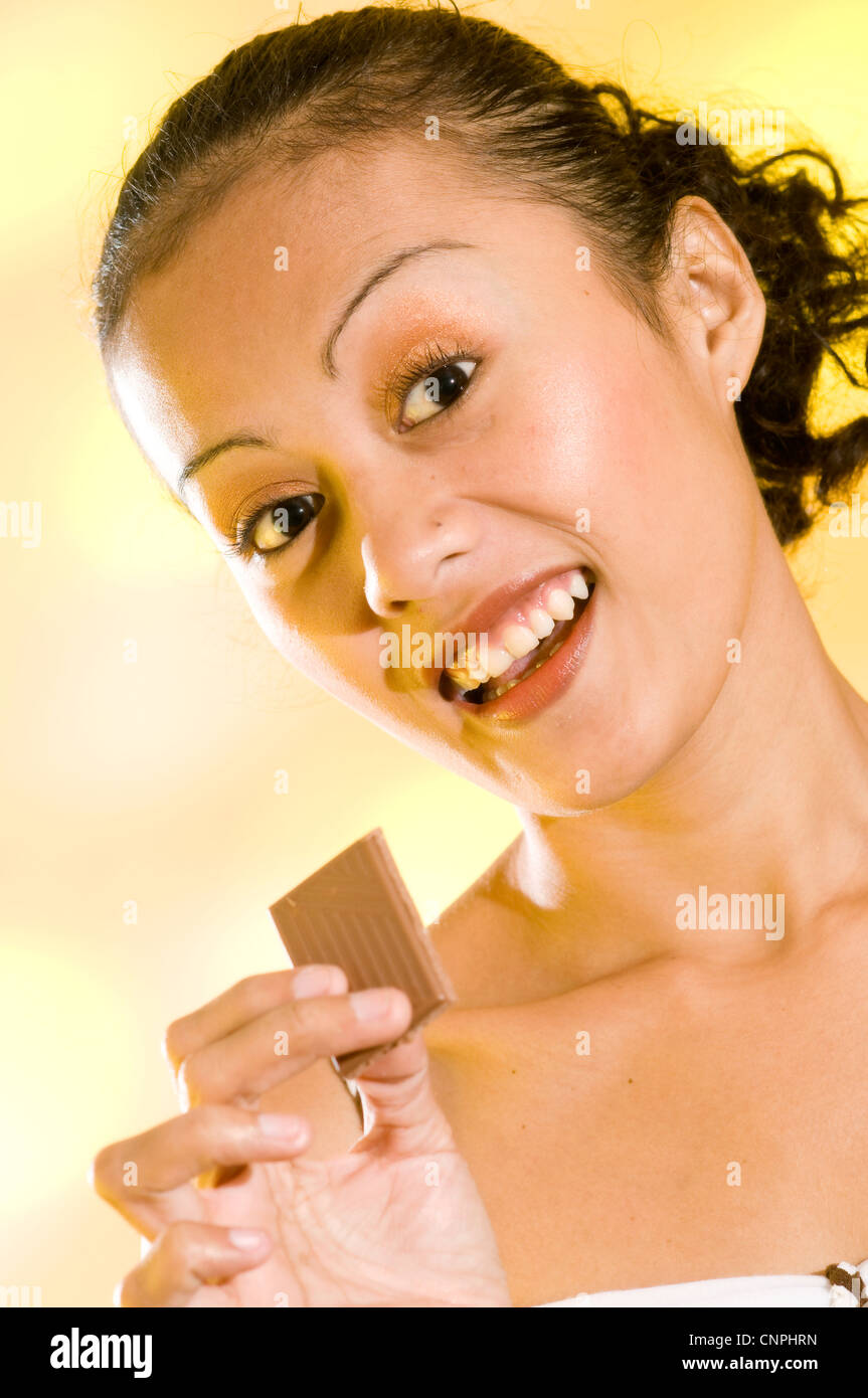 Asian model eating chocolate in studio setting Stock Photo - Alamy