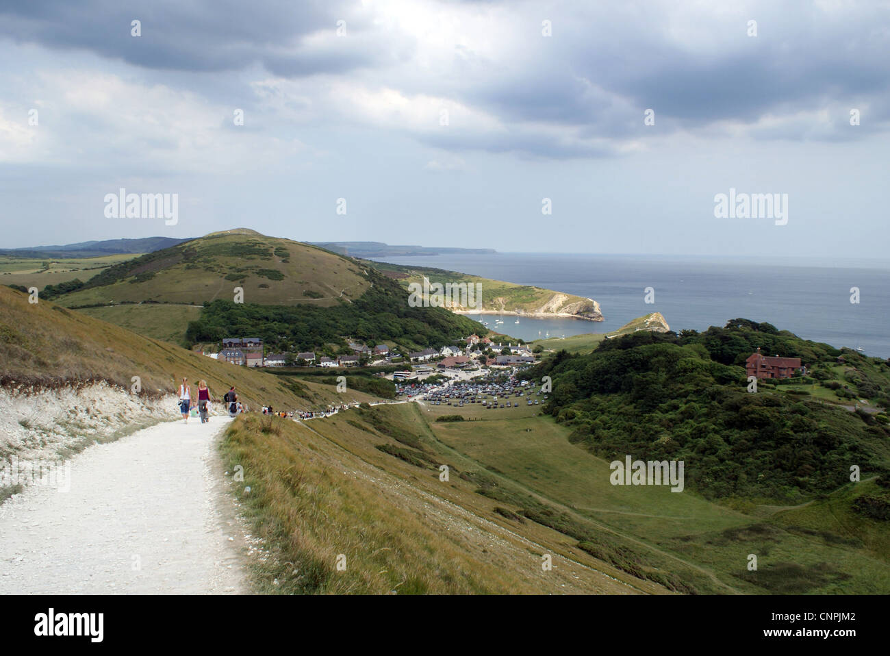 Long footpath leading down a hill towards sea Stock Photo - Alamy