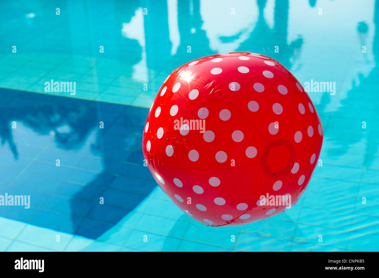 Floating red beach ball in swimming pool Stock Photo - Alamy