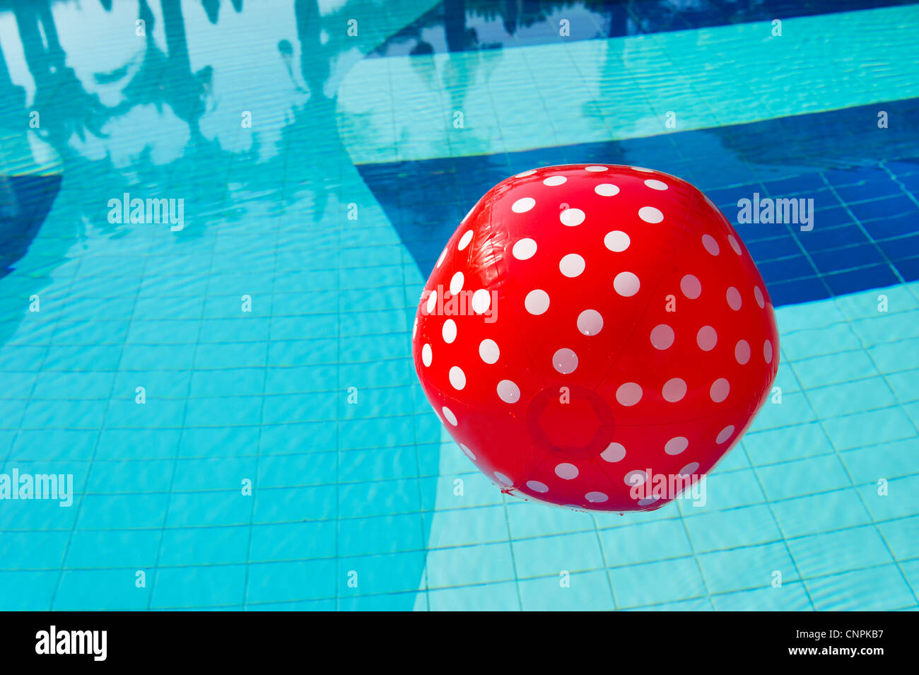 Floating red beach ball in swimming pool Stock Photo - Alamy