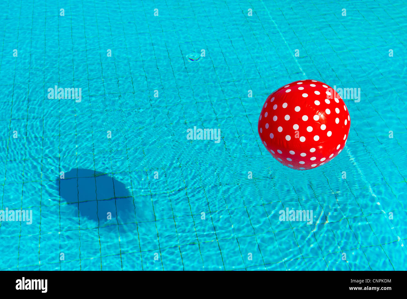 Floating red beach ball in swimming pool Stock Photo - Alamy