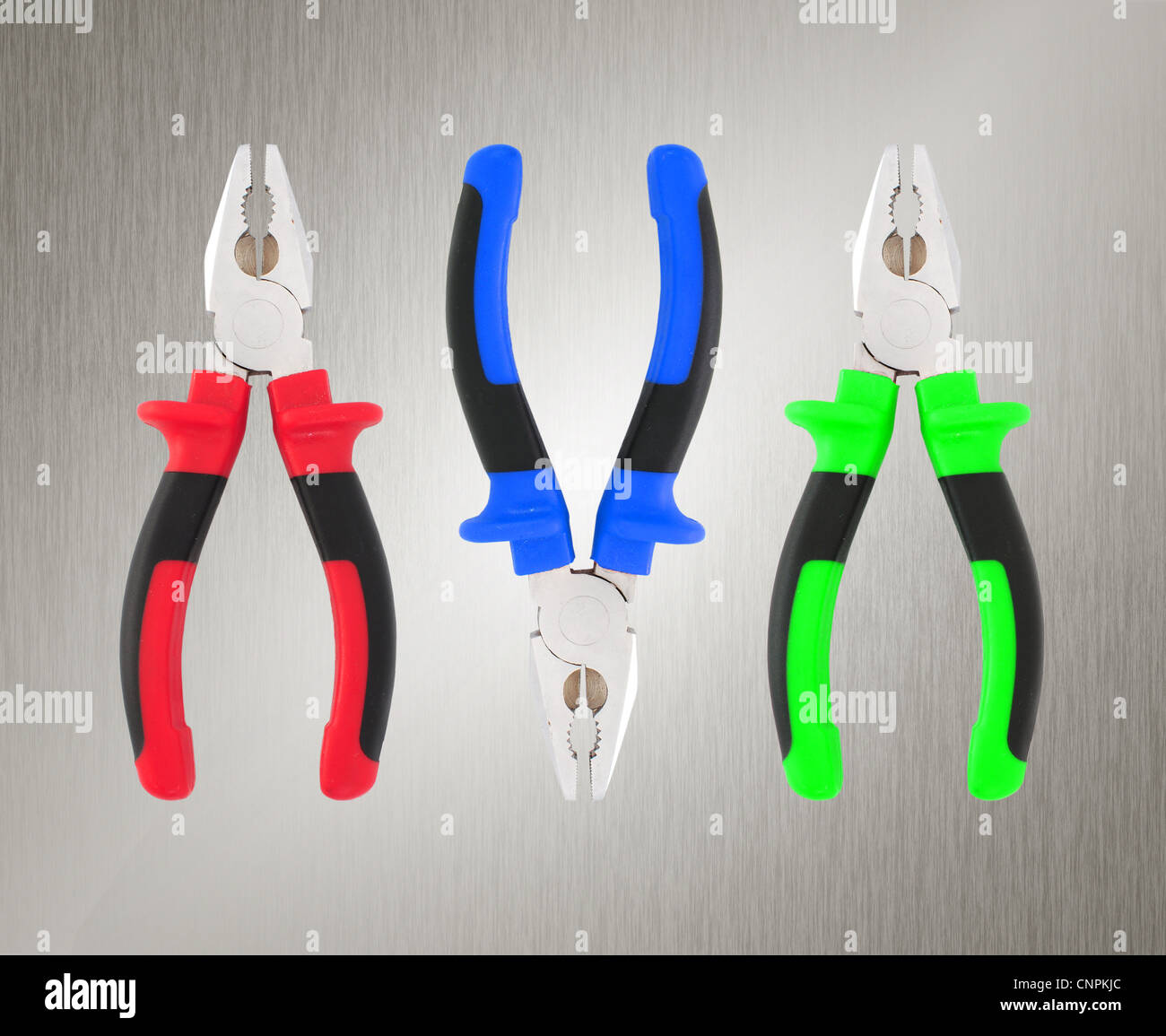 Three pliers with colorful handles on metal surface Stock Photo - Alamy