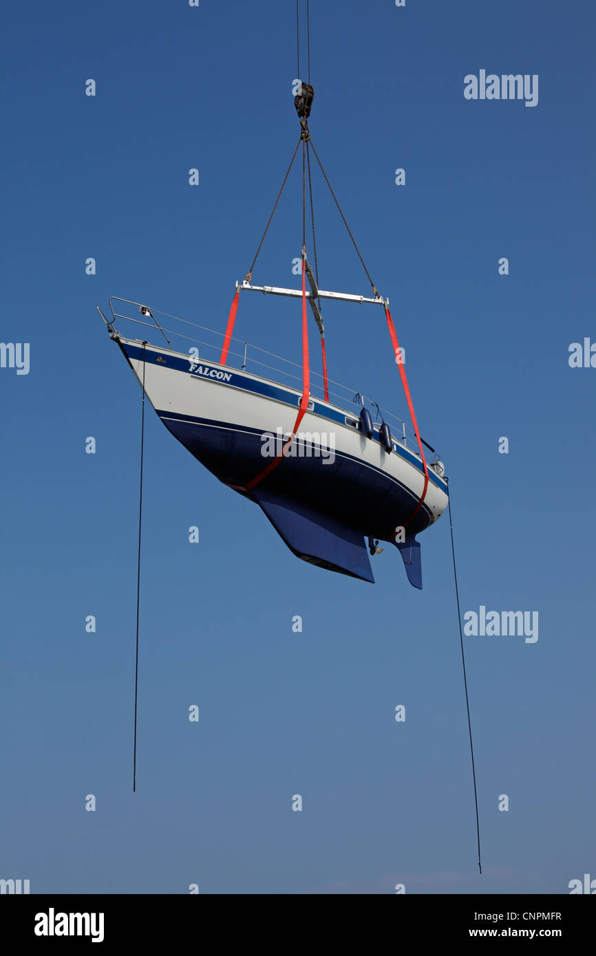 Sailing boat being hoisted into the harbour by a crane for the summer ...