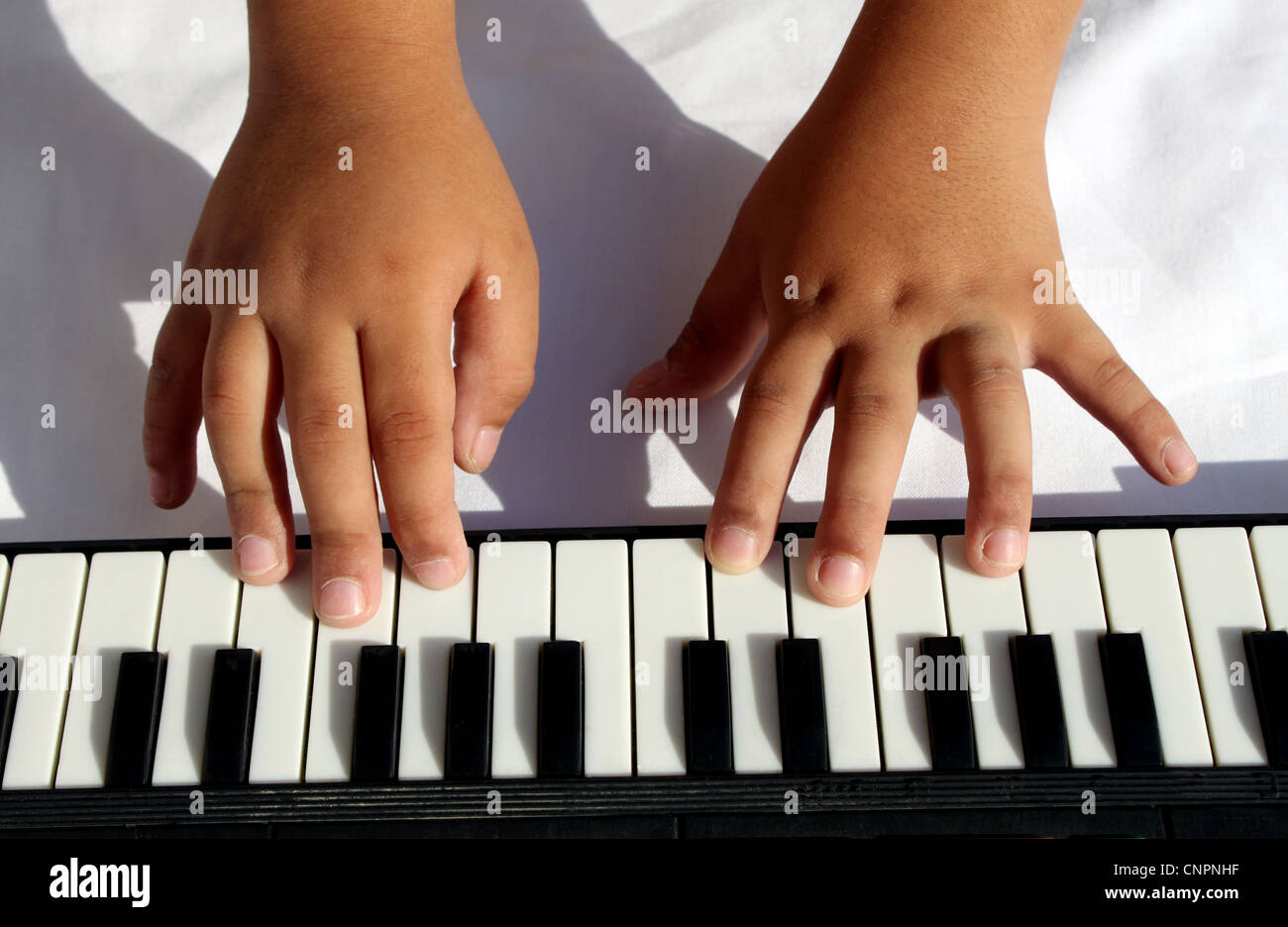 Child hands playing portable musical instrument Stock Photo - Alamy