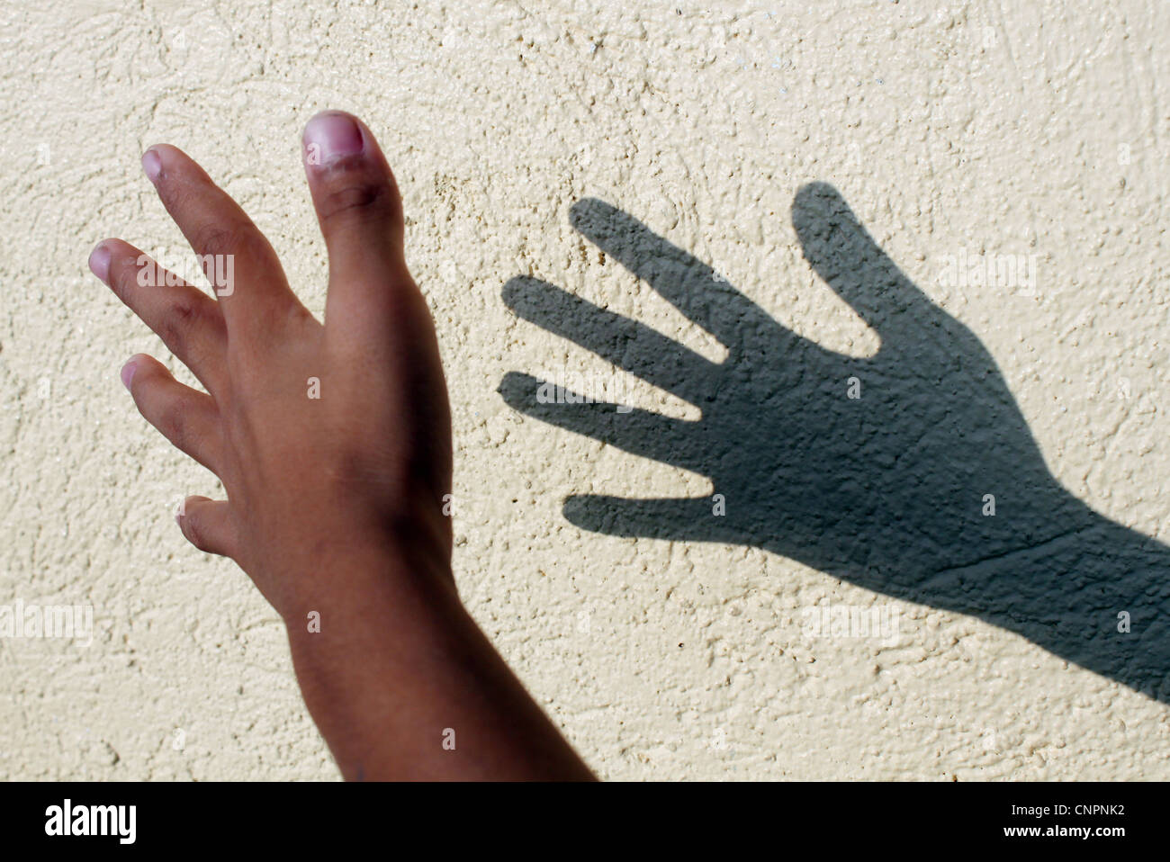 Child hand's against the sun creating a descriptive shadow on the ...