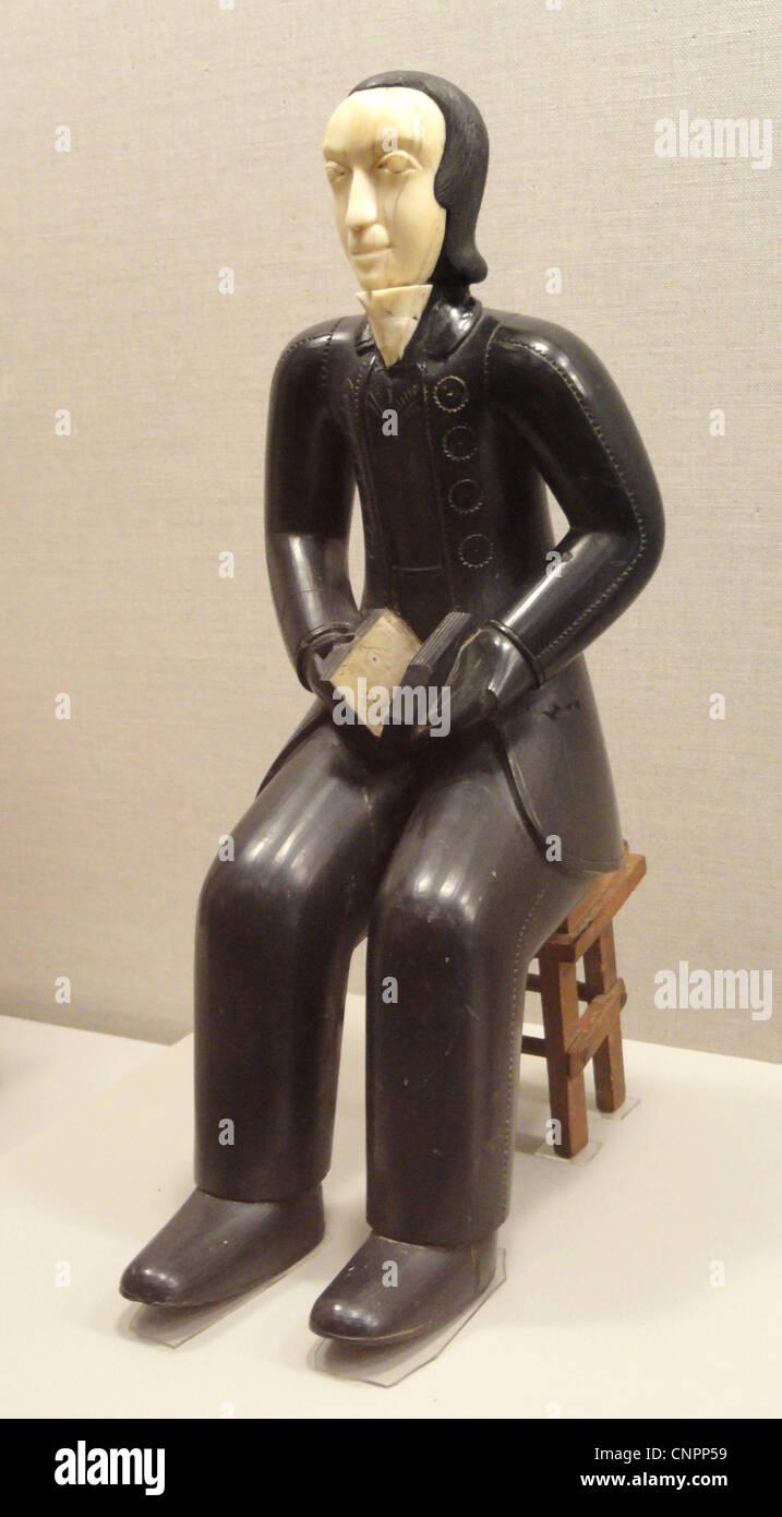 A slate and ivory figurine depicting a European, crafted by the Haida ...