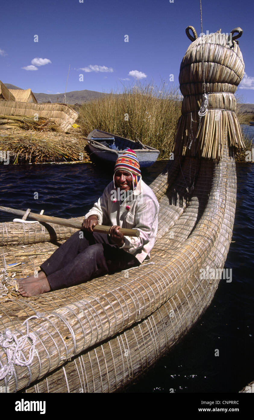 Man rowing a reed boat on Uros floating islands. Lake Titicaca, Peru ...