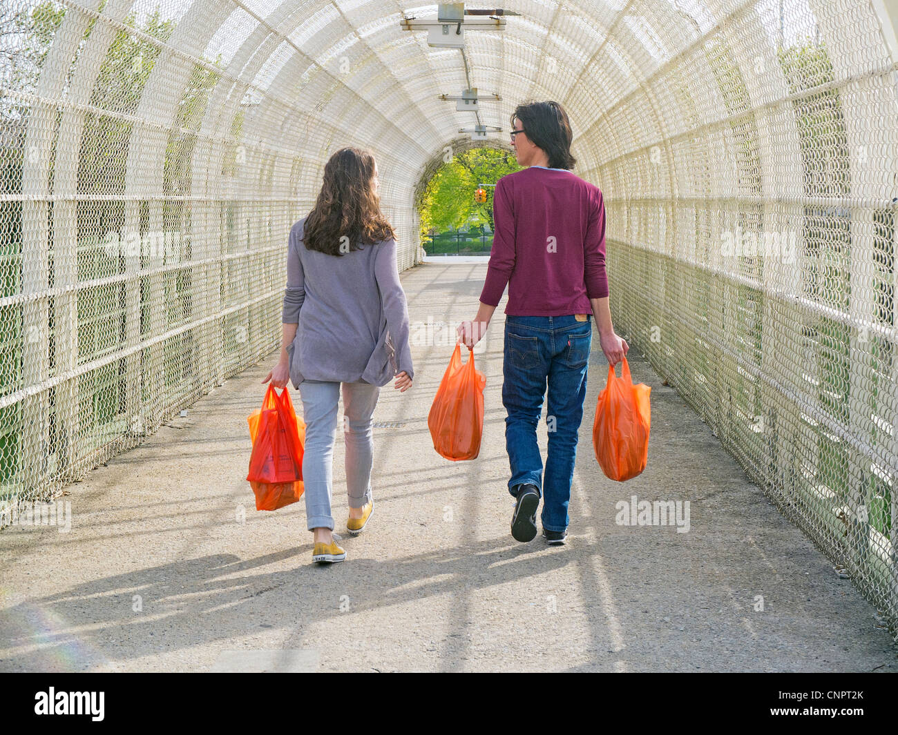 couple walking across an enclosed bridge of a highway in Windsor ...
