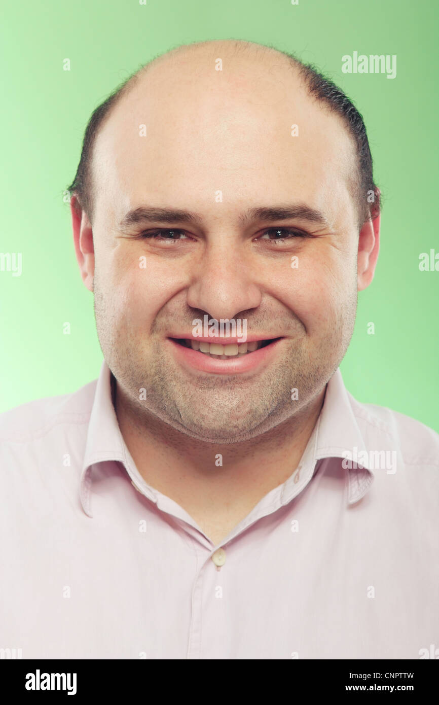 Portrait of a real smiling man in the studio on a green background ...