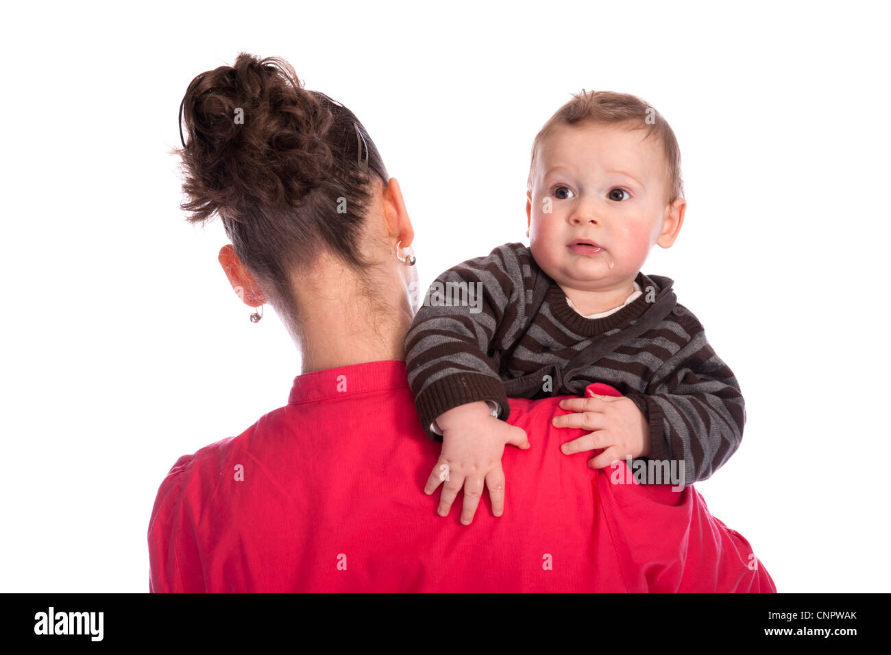 Baby looking over his mother's shoulder. On white background Stock ...