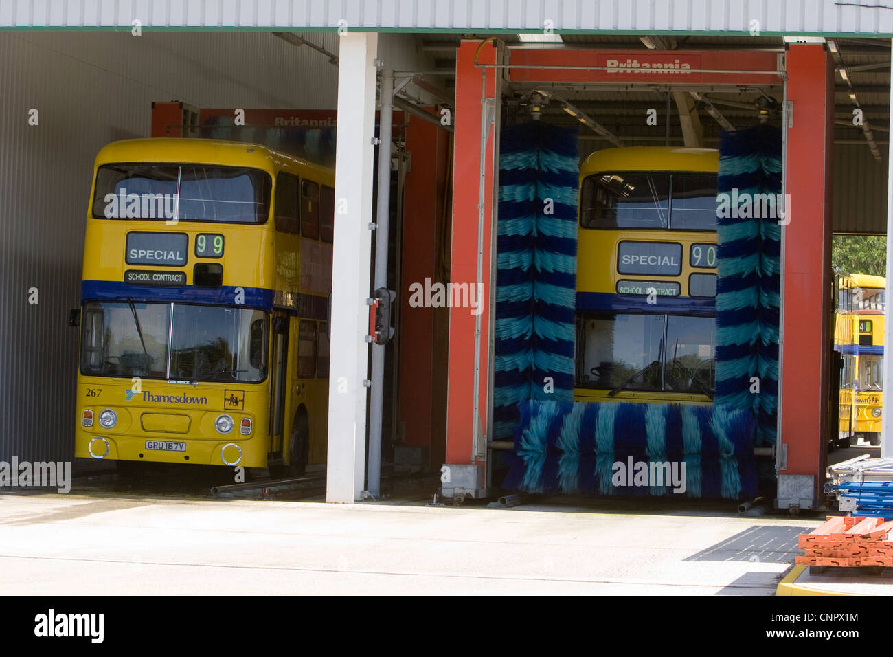 Double decker yellow school buses going through the automatic bus wash ...