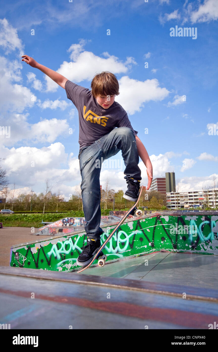 A young boy skateboarding and performing a jump on a ramp at a ...