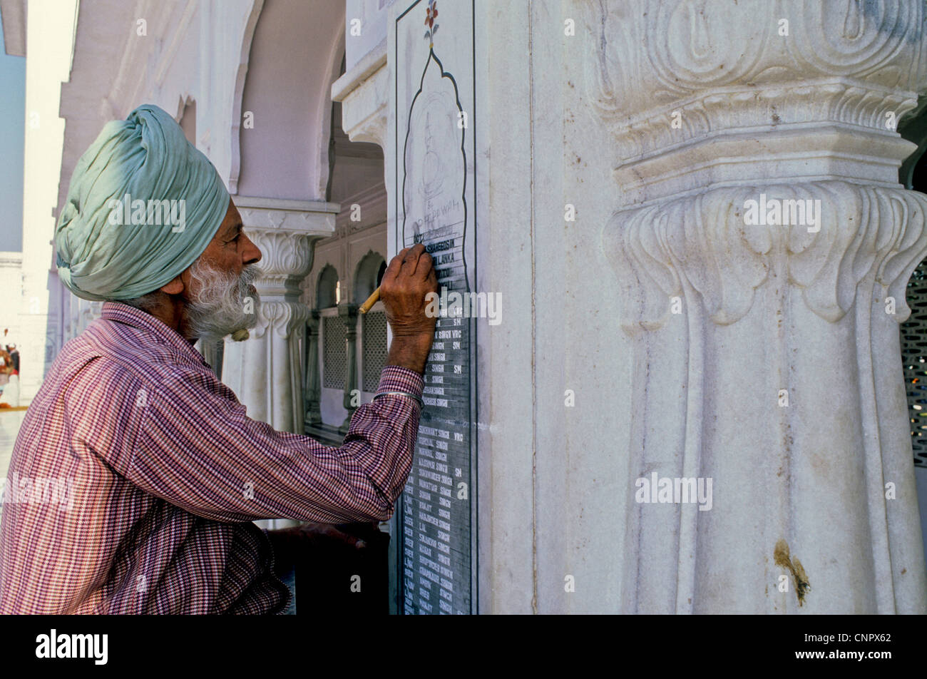 Sikh man writing on the walls of the Golden Temple in Amritsar. Main ...