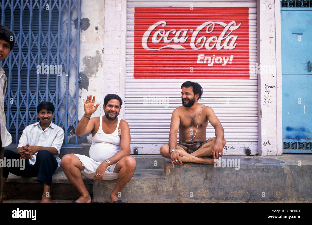 Group of Indian men in front a poster of coke at the ancient Indian ...