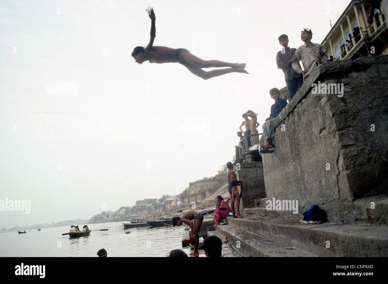 Indian boy jumping on the Ganges river at the ancient Indian city of ...