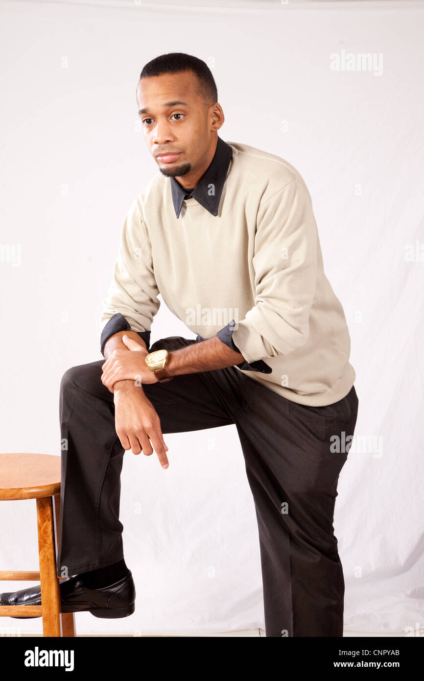 Handsome young black man with pensive expression resting and leaning on ...