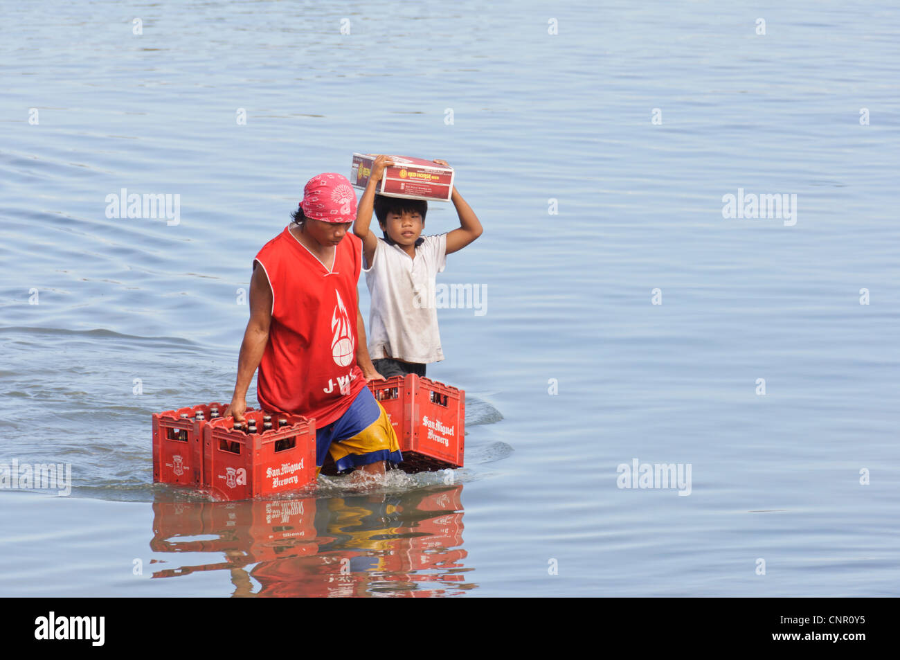 Asian Filipino man boy carrying San Miguel Brewery beer crates through ...