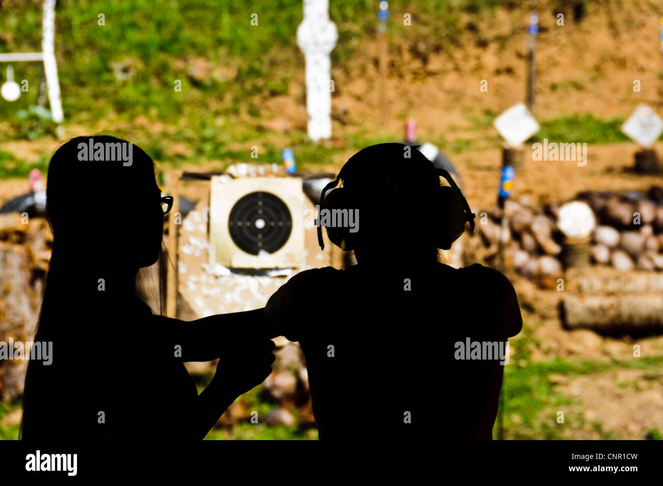 2 Women female shooter at firing shooting range wearing ear protector ...