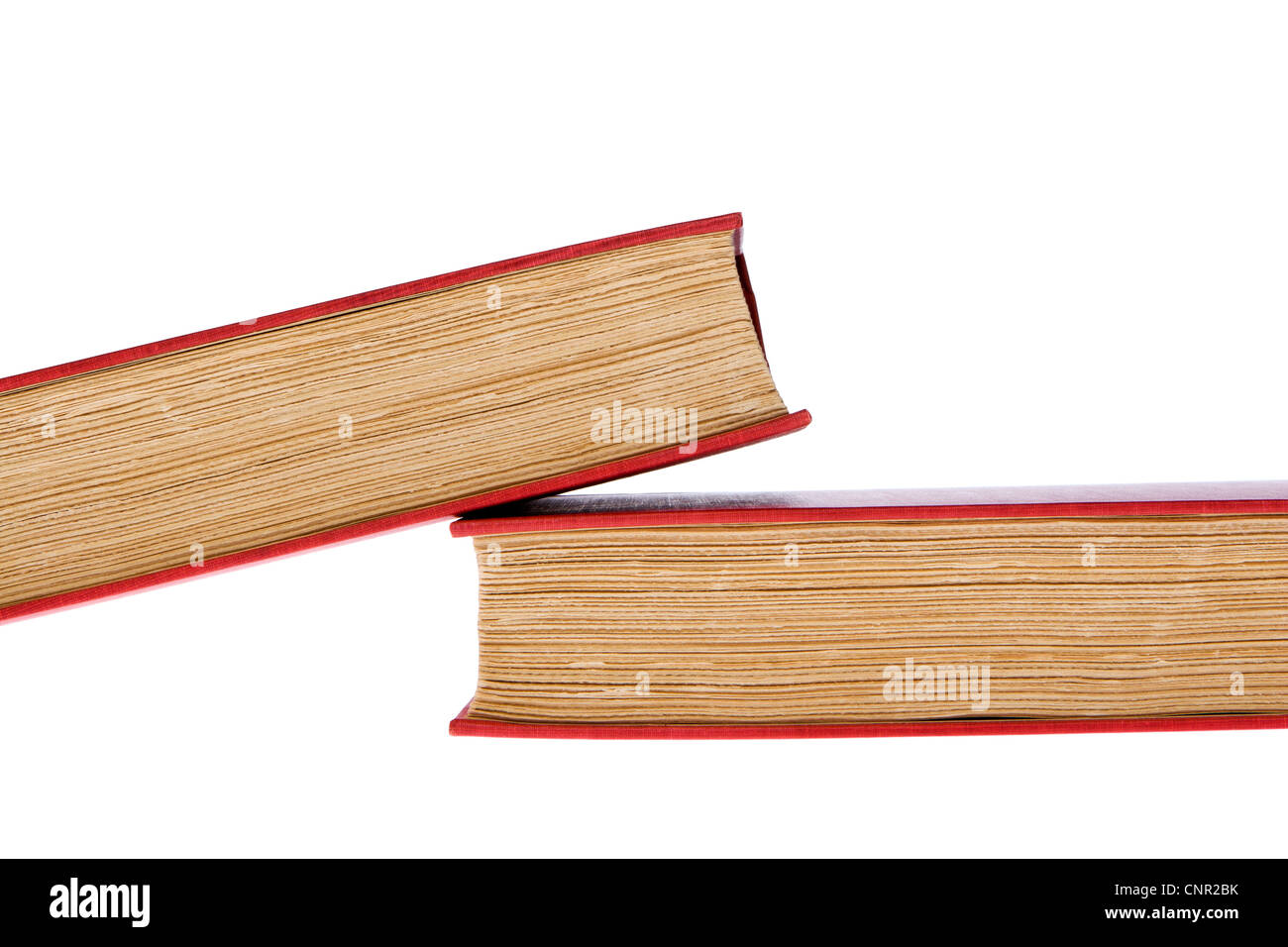 Two old red hardcover books, one leaning at an angle on the end of the ...