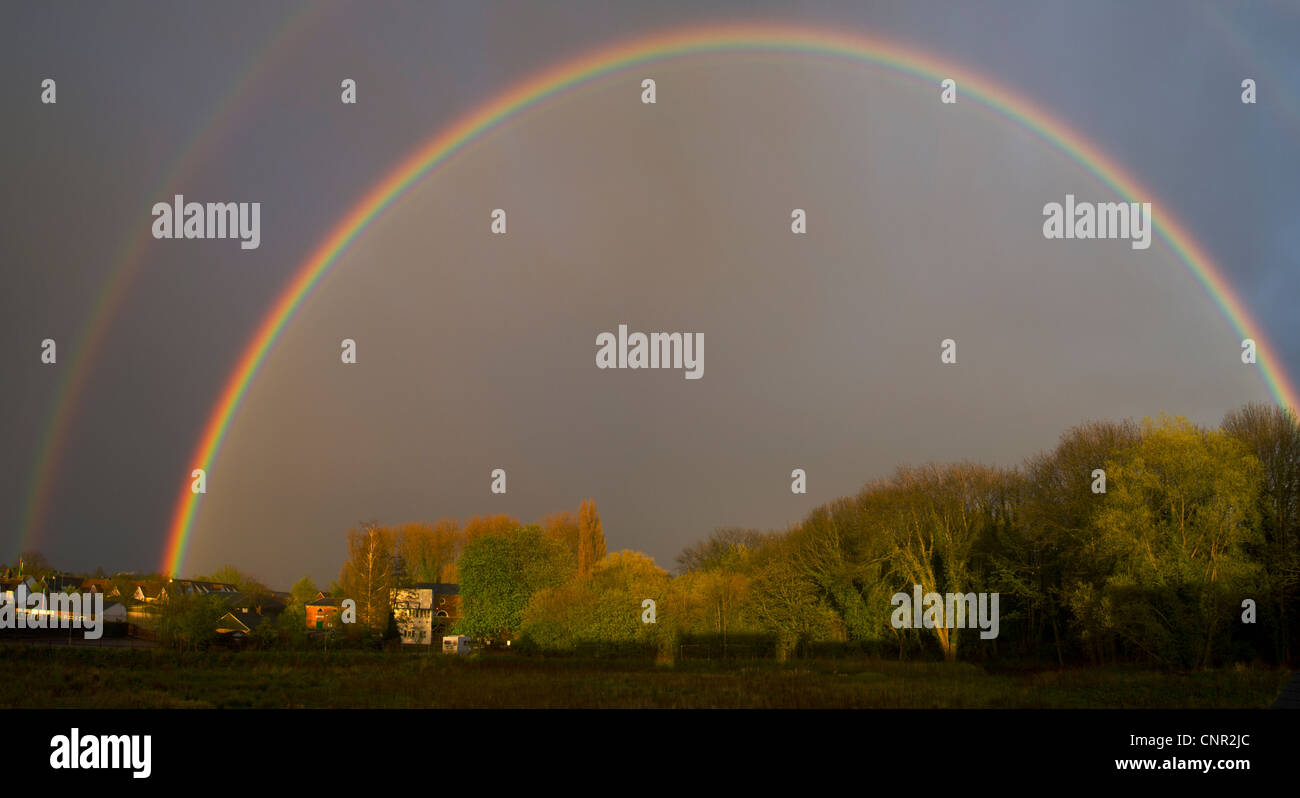 An early-evening full rainbow seen against the backdrop of a brooding ...