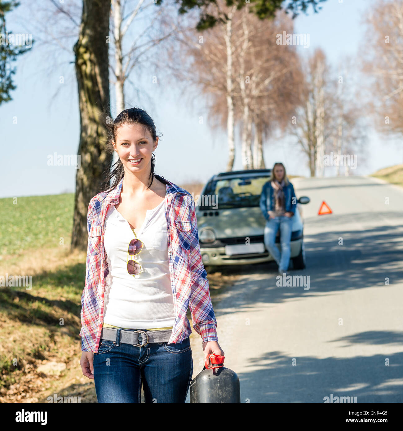 Running out of gas young woman walking for petrol can Stock Photo - Alamy