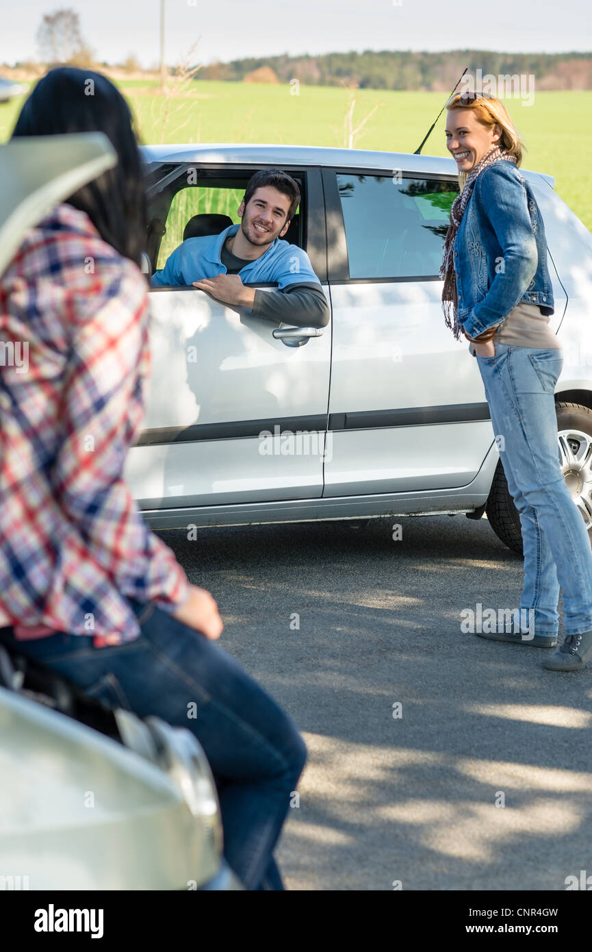 Car troubles two woman friends asking help young man Stock Photo - Alamy